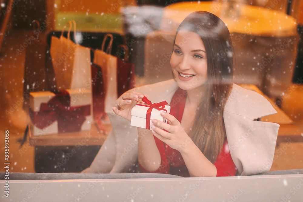 Portrait happy young beautiful woman open gift box, look in window and ...