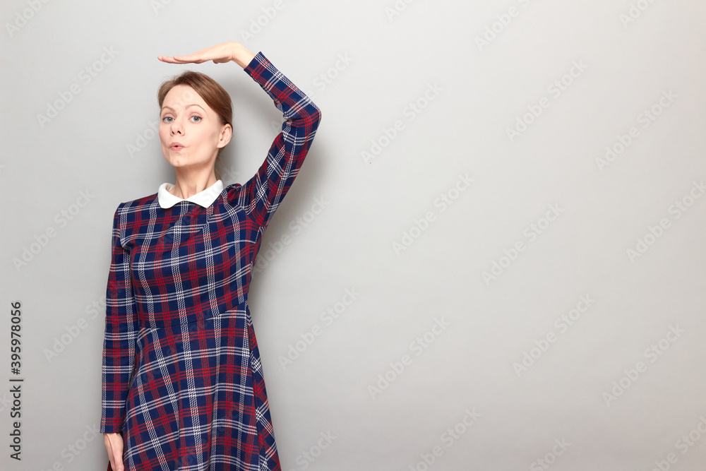 Girl is holding hand above head and measuring her height Stock Photo ...