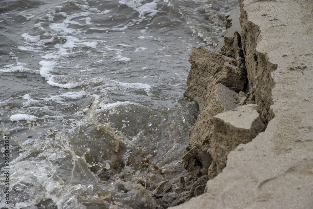 The sandy shore bursts into flood. Turbid water breaks the sand wall ...