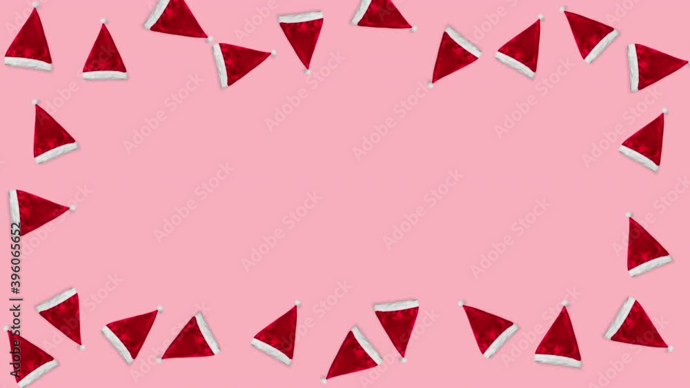 many red santa claus hats floating on a christmas pink background as a ...