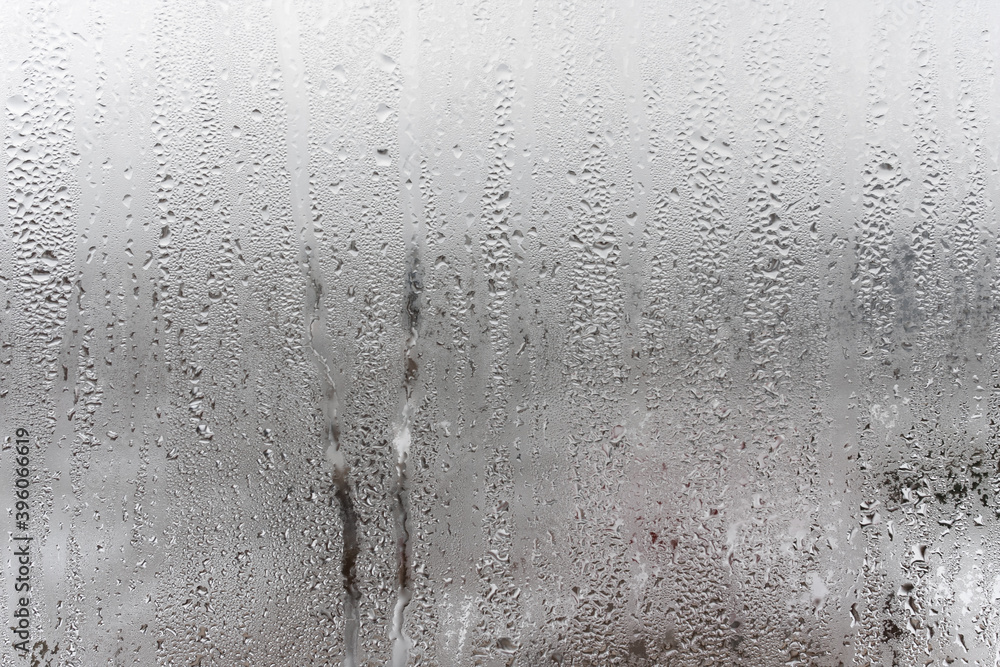 Natural drops of water flow down the glass, high humidity in the room ...