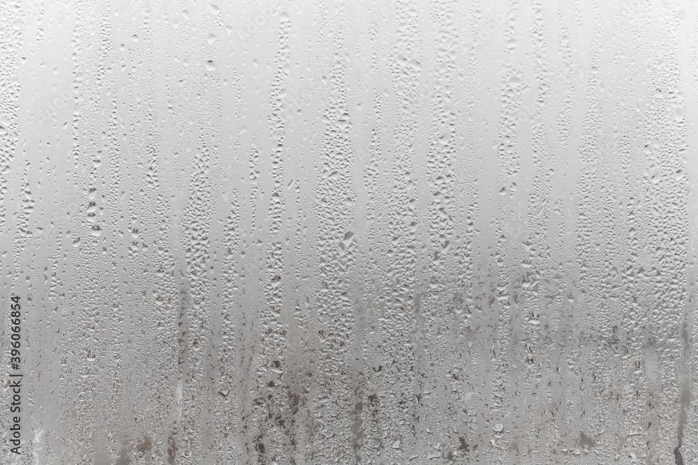 Close up for misted glass with droplets of water draining down ...