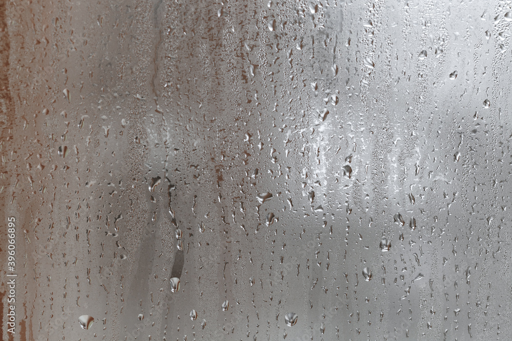 Close up for misted glass with droplets of water draining down ...
