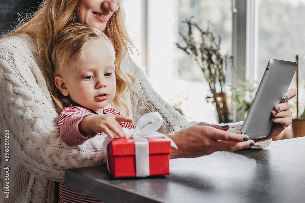 New year gifts concept. Mother and child open New Year's red gift box ... New year gifts concept. Mother and child open New Year's red gift box ...
