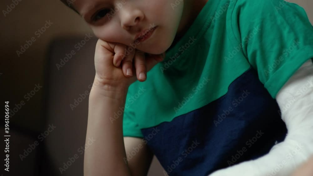 little boy lies on the bed with a fractured limb. a child's arm is ...