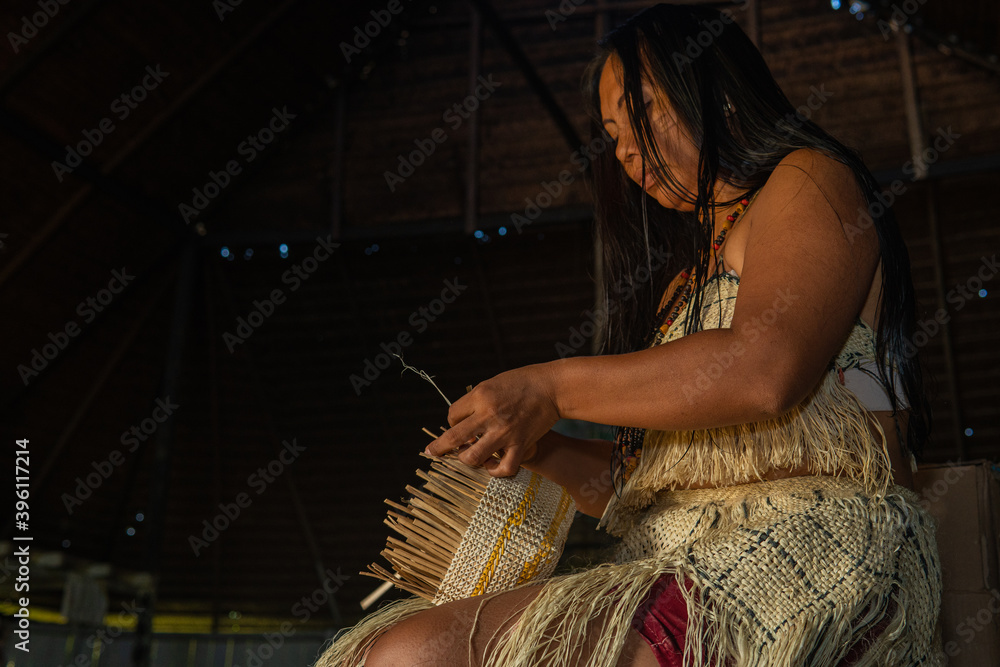 indigenous woman from the uitoto tribe of the colombian amazon weaving ...