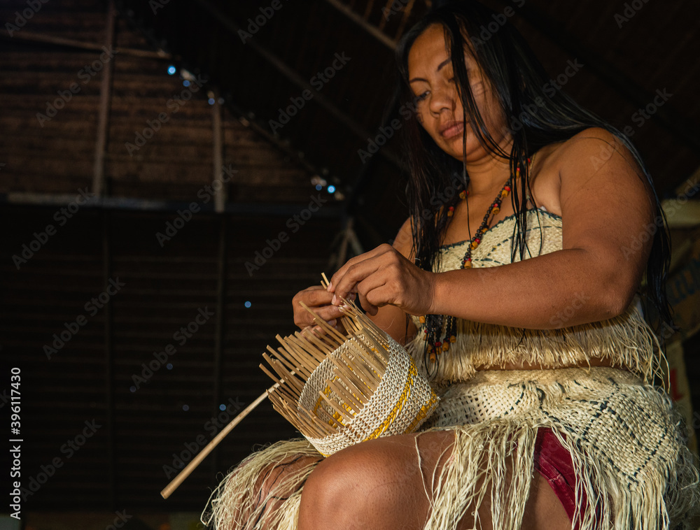 indigenous woman from the uitoto tribe of the colombian amazon weaving ...