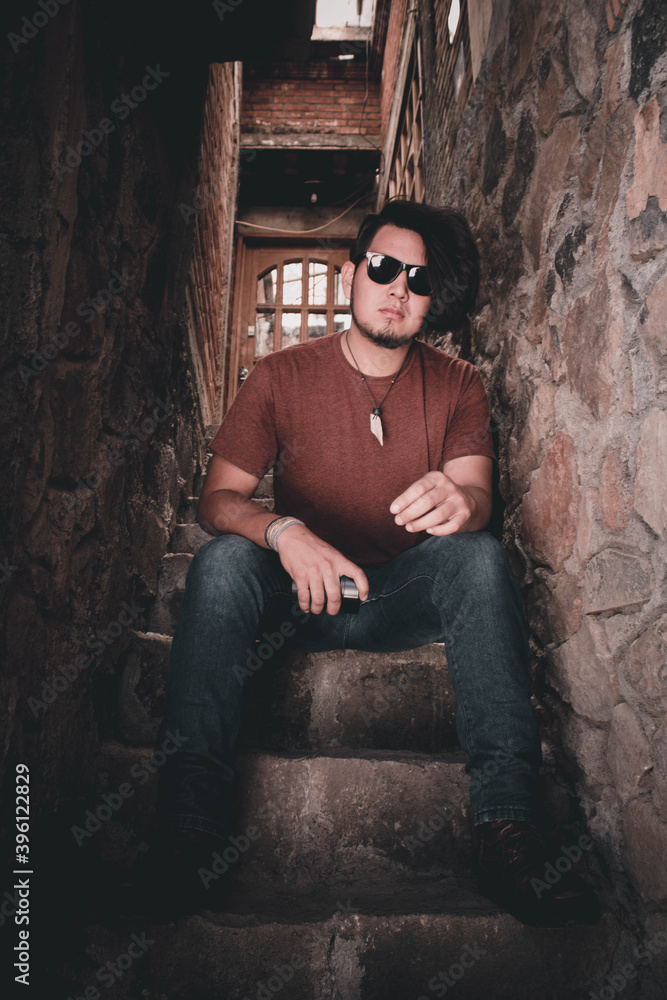 Hombre posando en la entrada de una casa entre dos muros de roca Stock ...