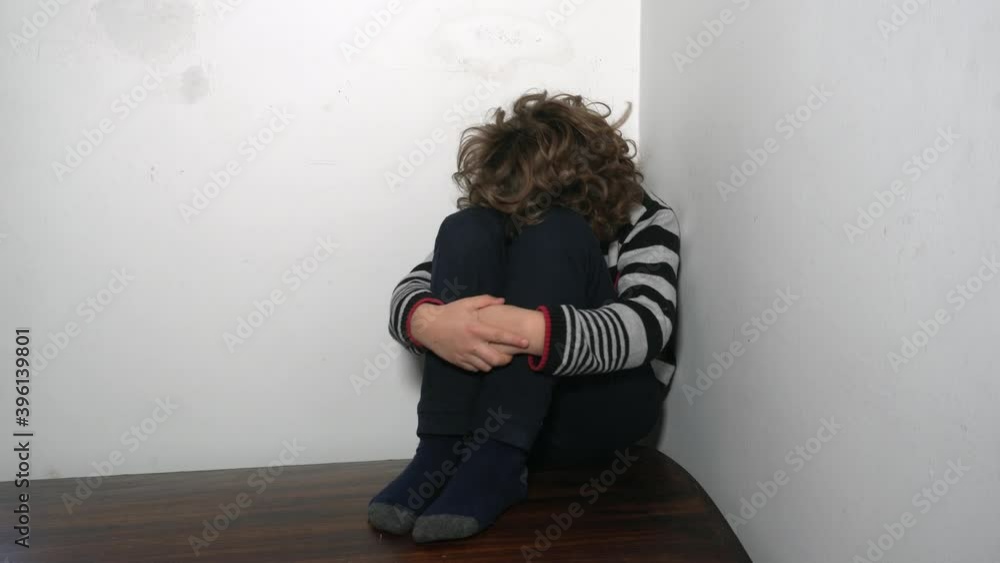 sad upset boy sitting in corner lifestyle . Child punished sitting ...