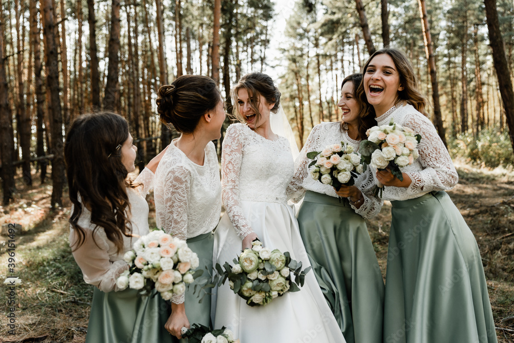 beautiful laughing girls in wedding dresses hold bouquets with flowers ...