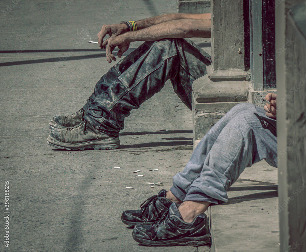 Homeless men smoking cigarettes outdoors in shelter doorways, cigarette ...