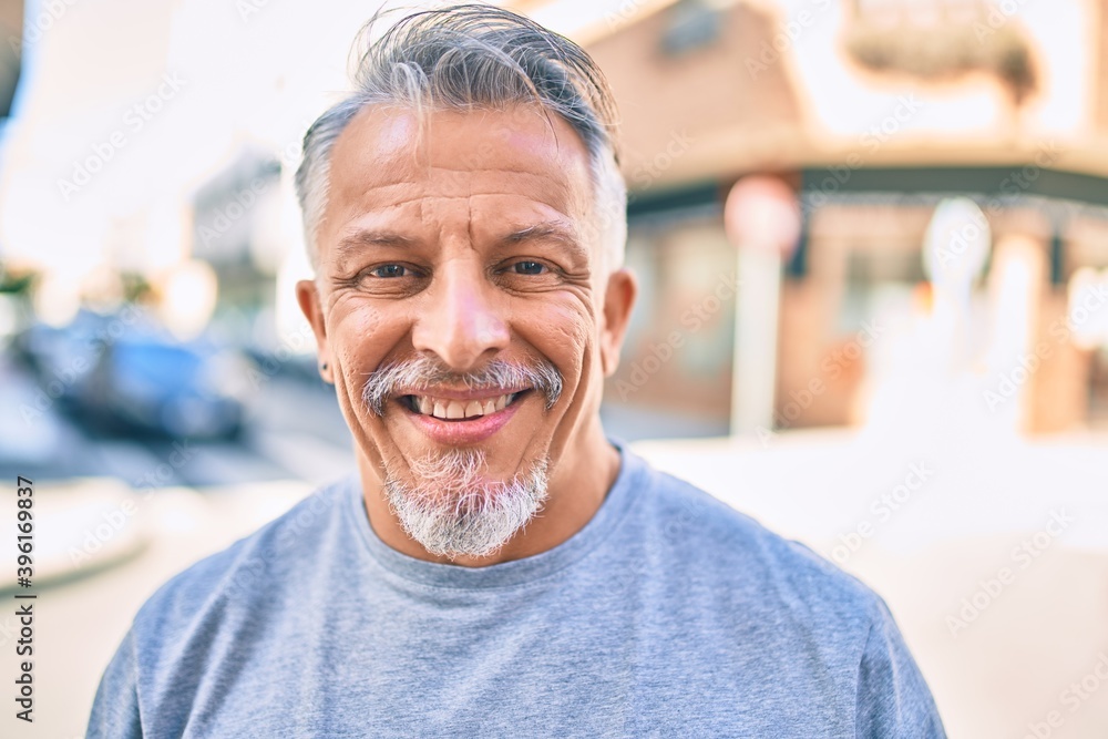 Middle age hispanic grey-haired man smiling happy standing at the city ...
