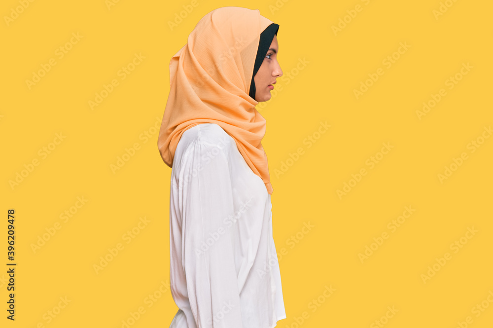 Young brunette woman wearing traditional islamic hijab scarf looking to ...