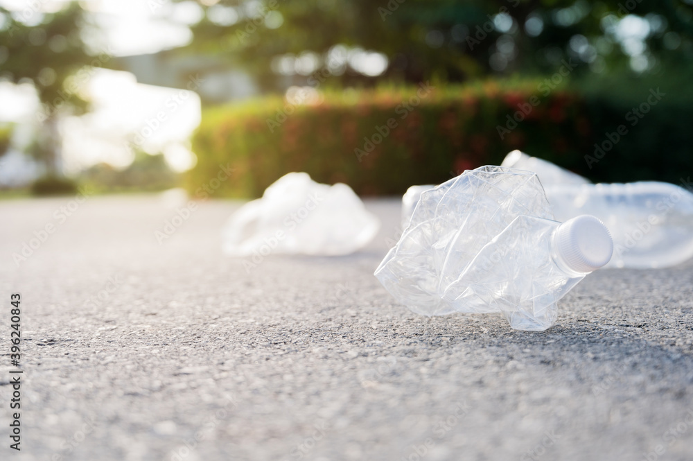 Plastic bottles and plastic bags in the park. A lot of plastic waste is ...