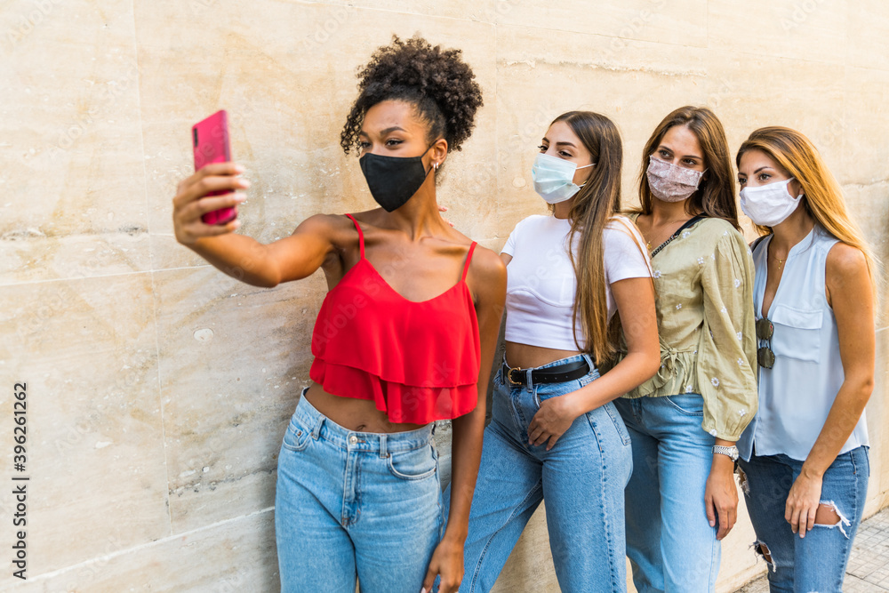 Selfie of young smiling people having fun together wearing face mask ...
