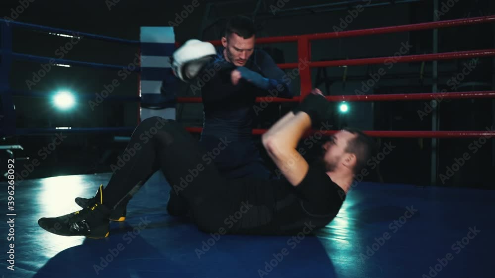 Professional boxers in black sportswear doing abdominal exercises on ...