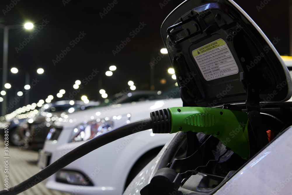 Green power supply connector in grey electric car at the parking at ...