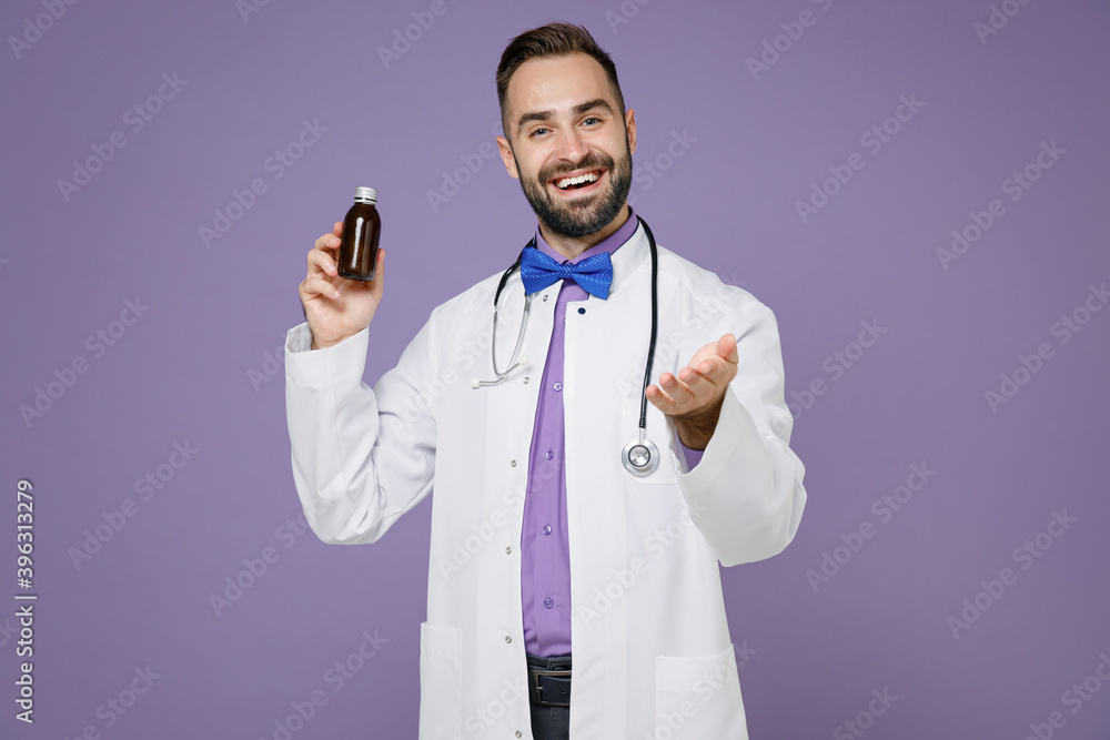 Smiling young bearded doctor man in white medical gown stethoscope hold ...