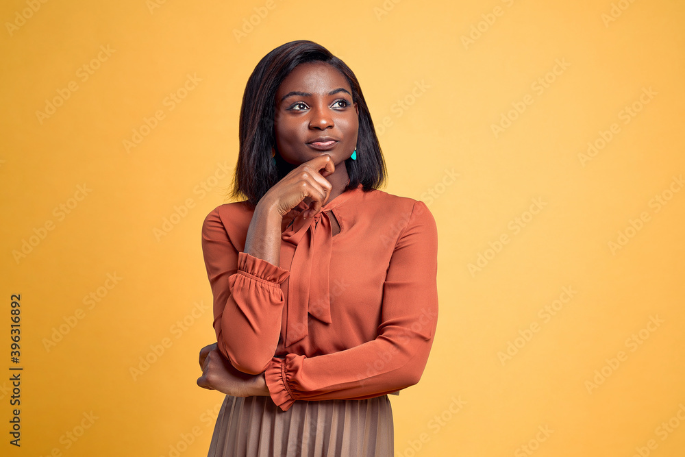 Woman wearing isolated yellow background with hand on chin thinking ...