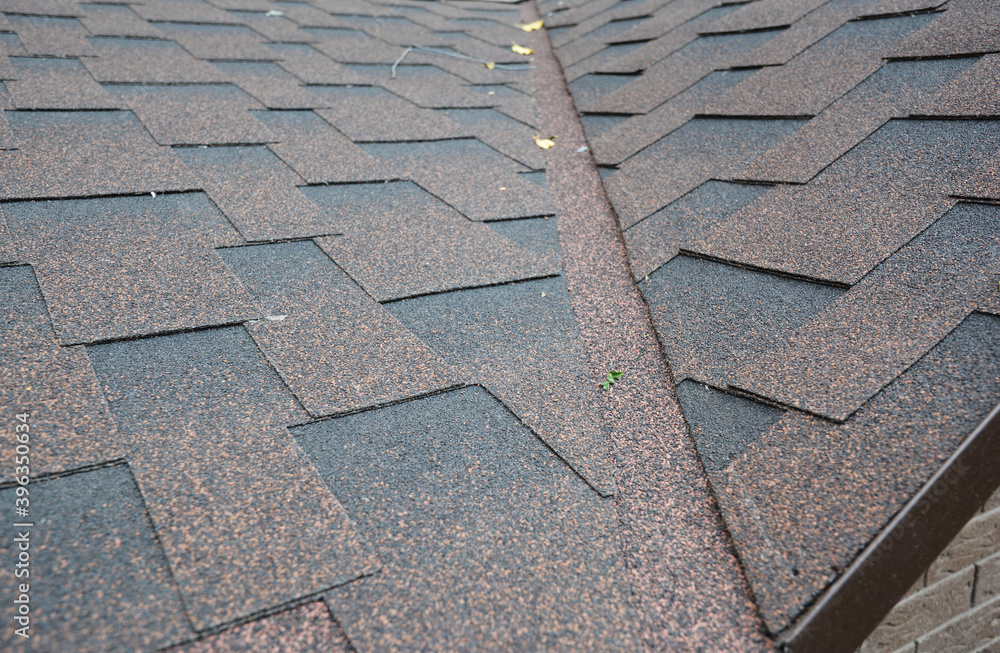 A close-up of asphalt shingled roof corner, roof intersection with roof ...