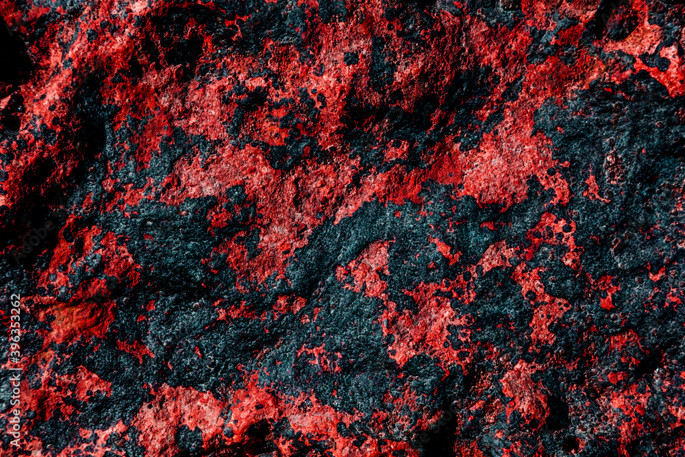 Top view of a dark rock with red spots in all the frame.Stone texture ...