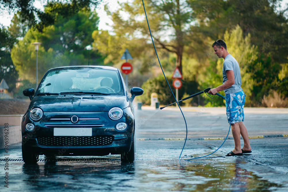 Manual car wash with water under pressure in a car wash on the street ...