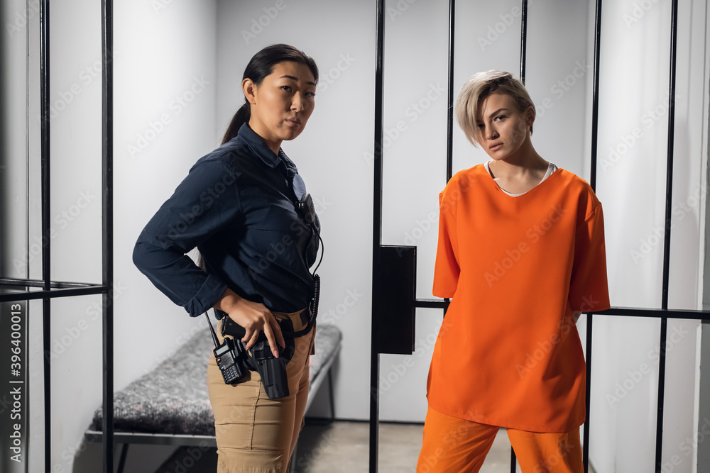 Blonde inmate in an asian women's general security prison is led out of ...