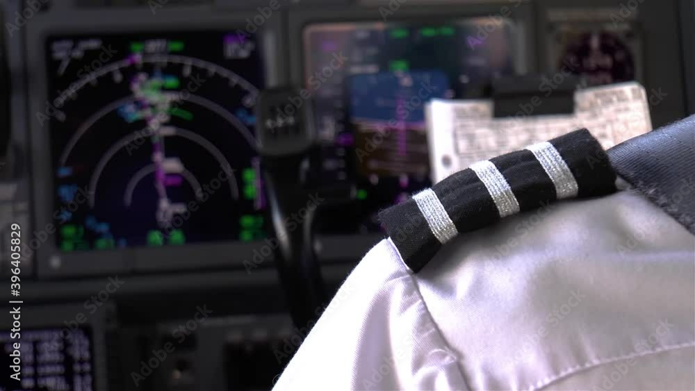 Pilot in the flight deck of a modern airliner. A pilot monitors the ...