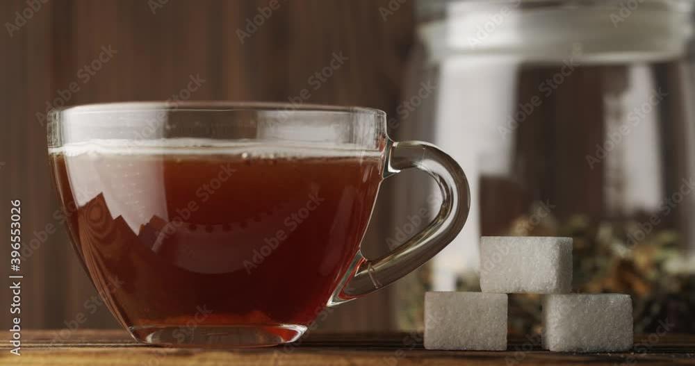 Sugar is dissolved in a clear glass Cup with hot tea closeup, slow ...