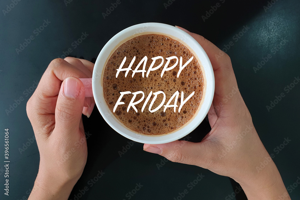 Hand holding a coffee cup with Happy Friday quote on black background ...
