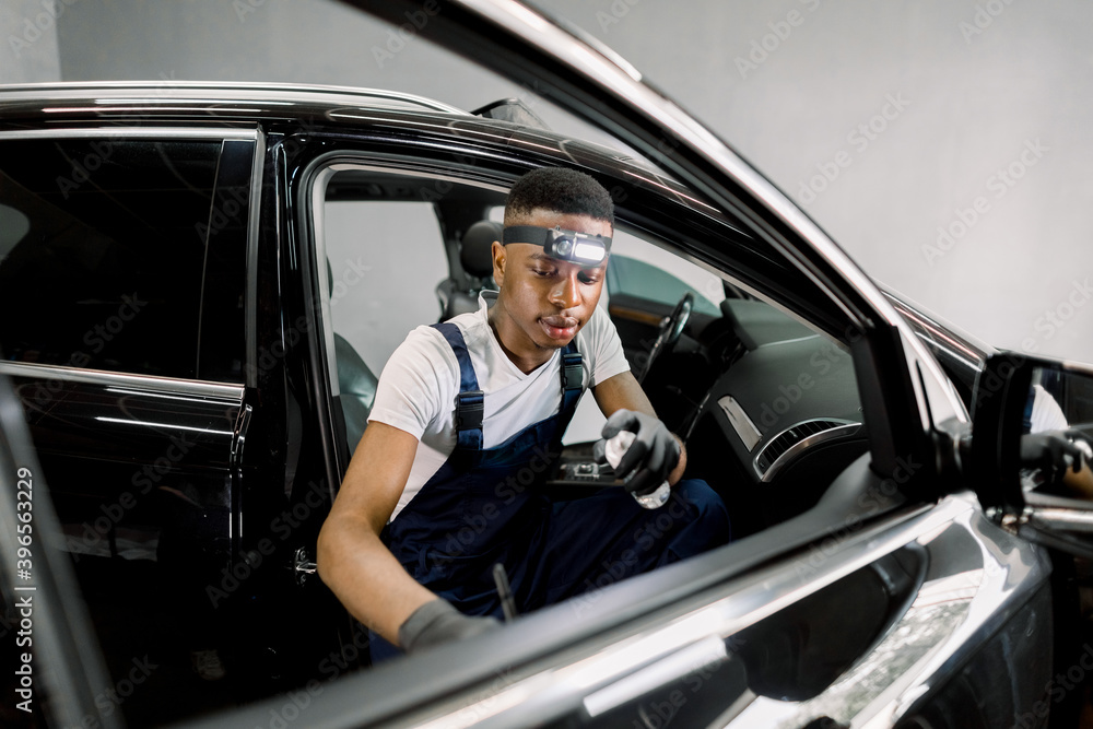 Front view of young black male worker in uniform, providing ...