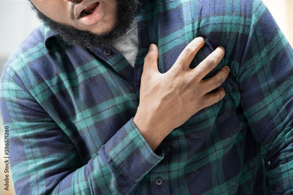 sick african man with heart attack or chest pain; portrait of african ...