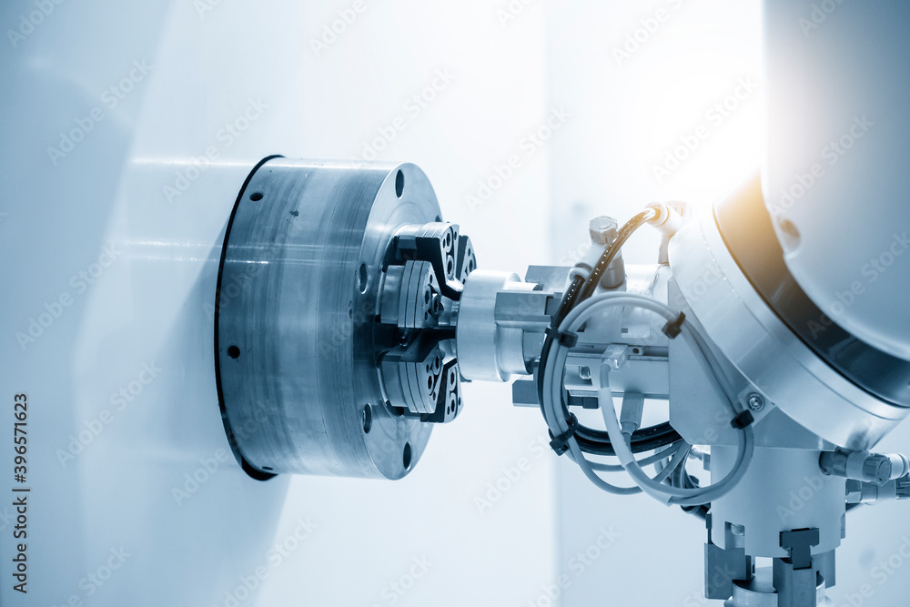 The robotics arm gripping the metal part from CNC lathe machine. The hi ...