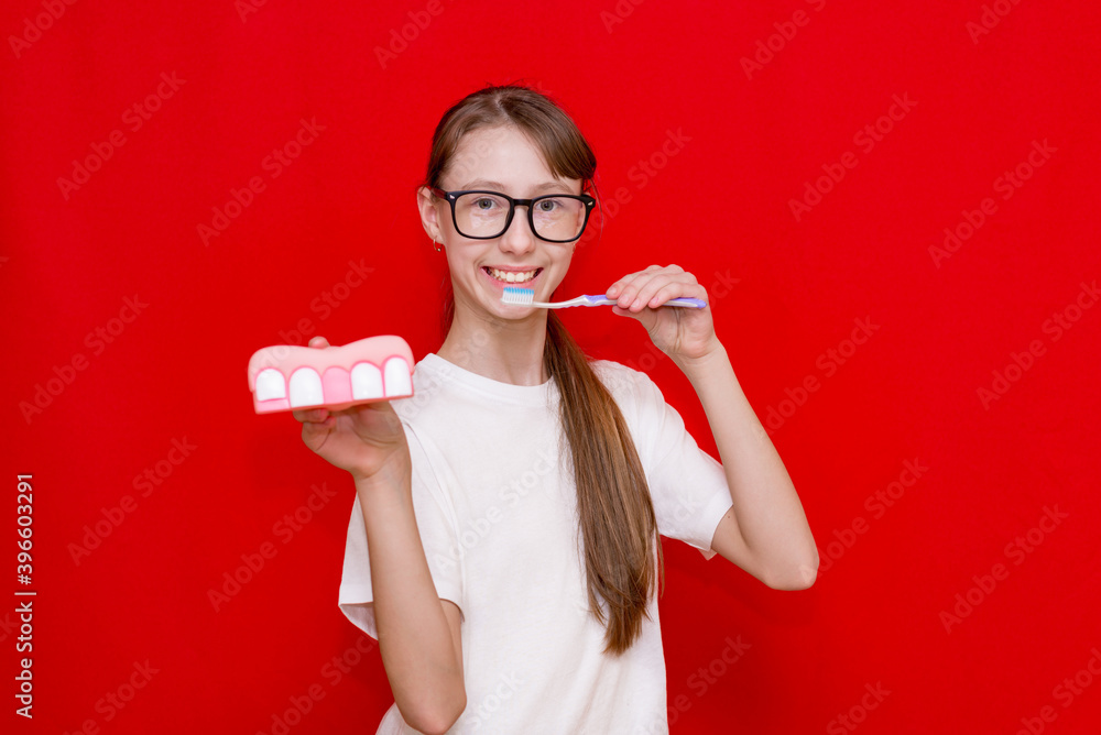 Teenager girl demonstrating brushing teeth holding plastic dental ...