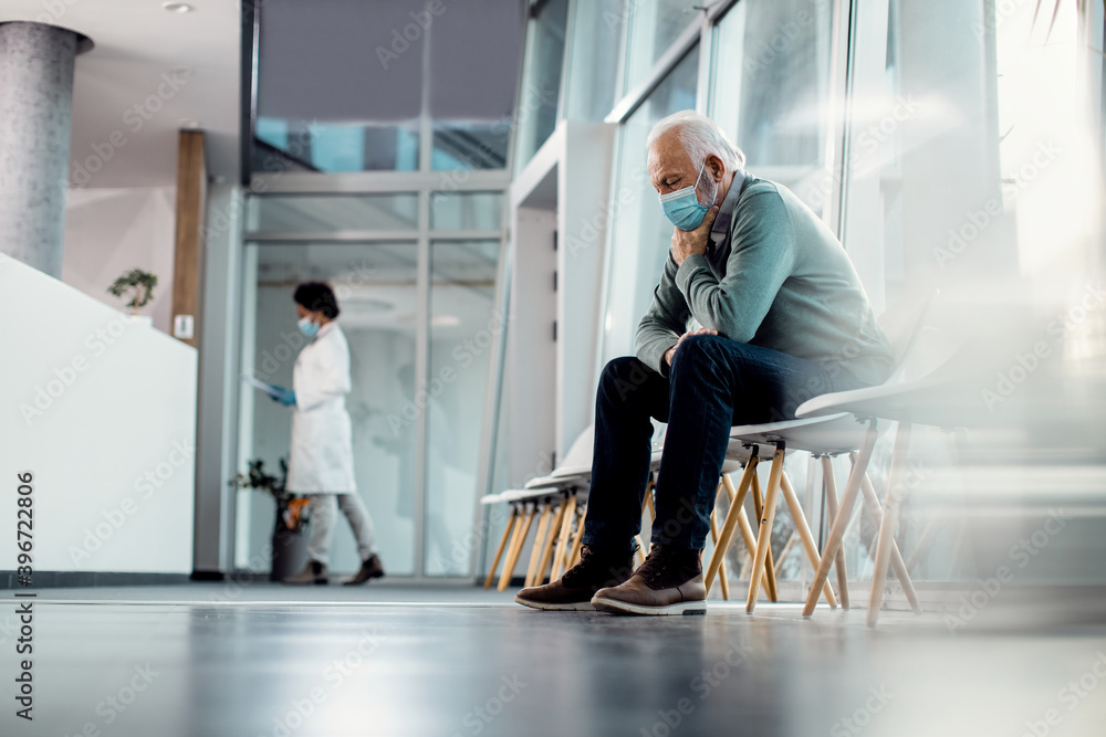 Worried senior man thinking of something while sitting in hospital ...