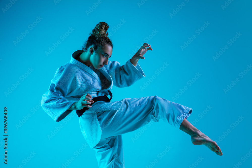 Active training. Professional female judoist in white judo kimono ...