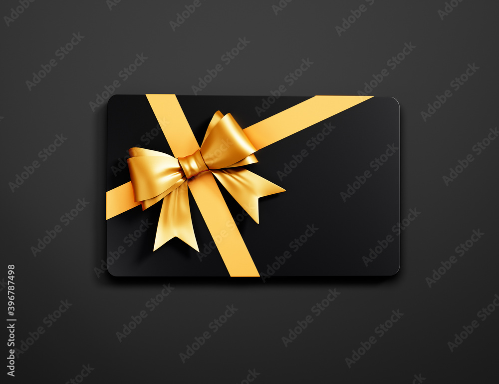 Black credit or gift card with golden ribbon isolated on dark ...