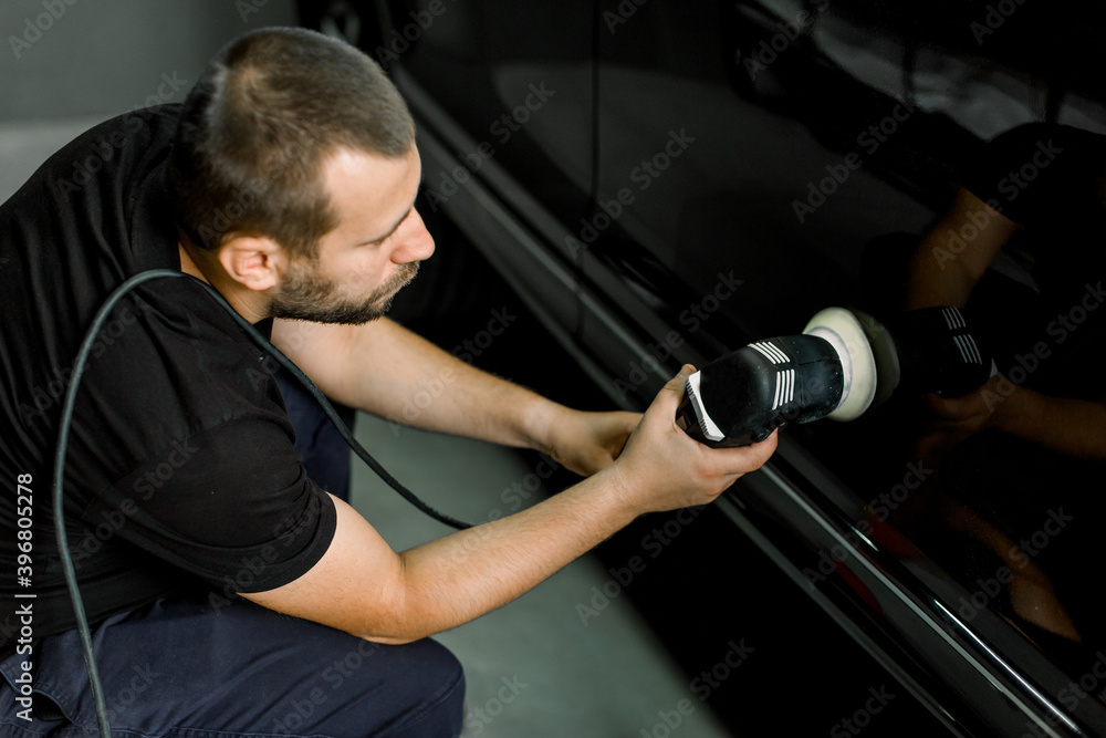 Car service worker polishing modern vehicle body with special wax from ...