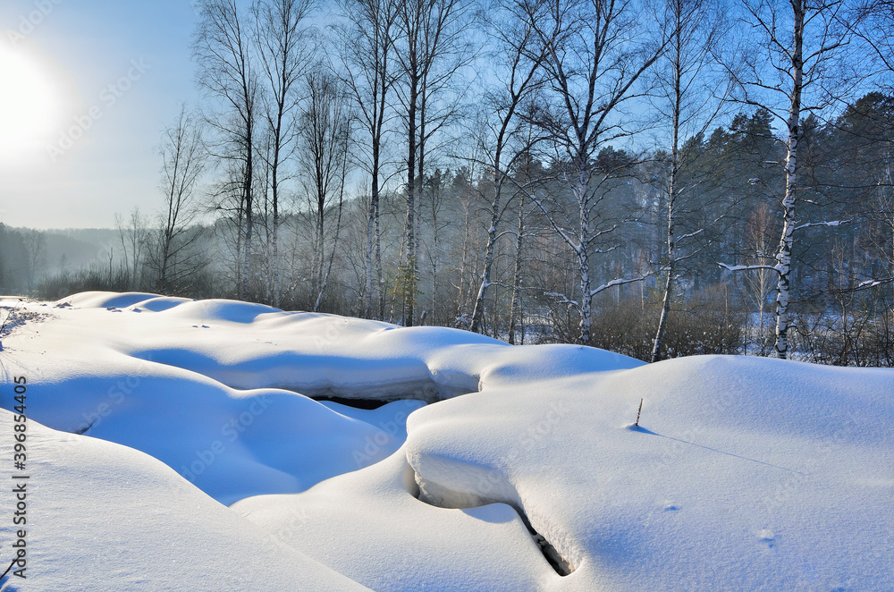 Soft bizarre curves of snow surface near the winter forest. Twisty ...