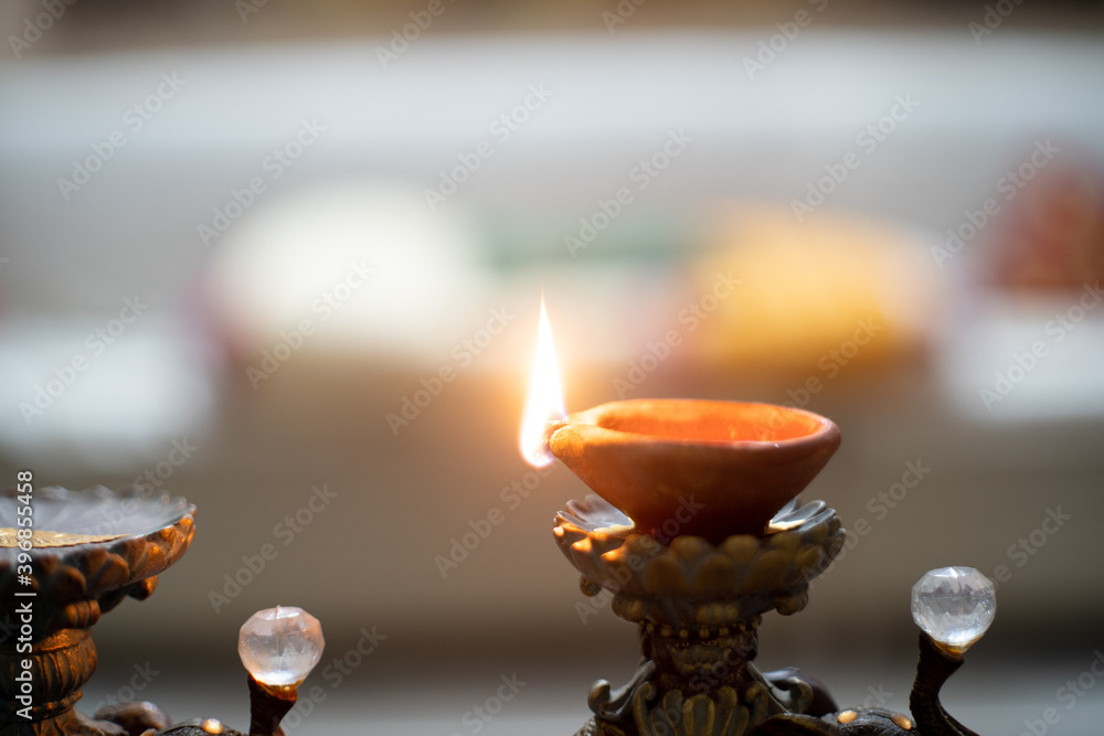 Panning shot of a diya placed indoors with out of focus background of a ...