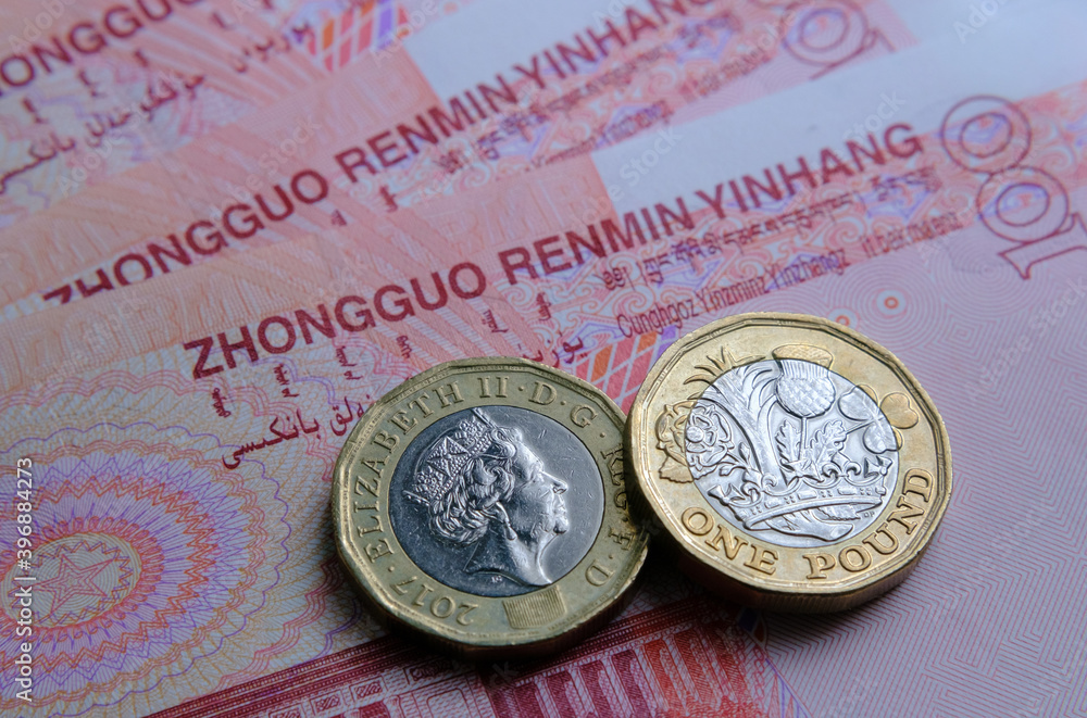 One pound coins placed on top of 100 Chinese yuan renminbi banknotes ...