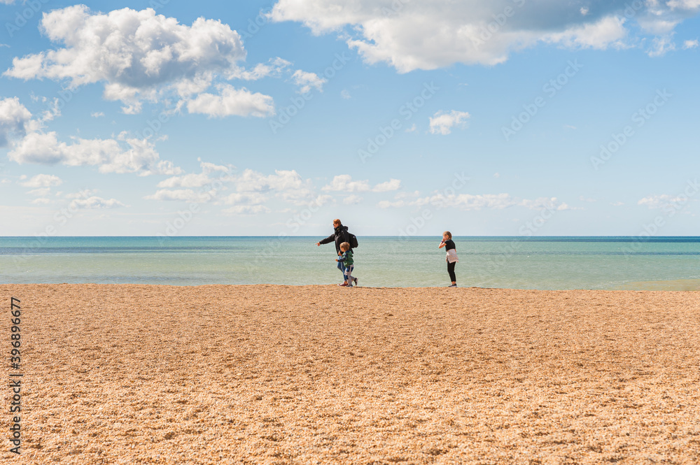 Family day out at the beach during sunny but windy day. Children ...