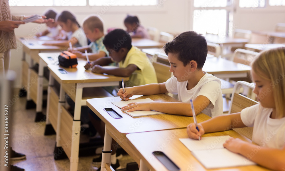 School children writing test, smart young people studying at primary ...