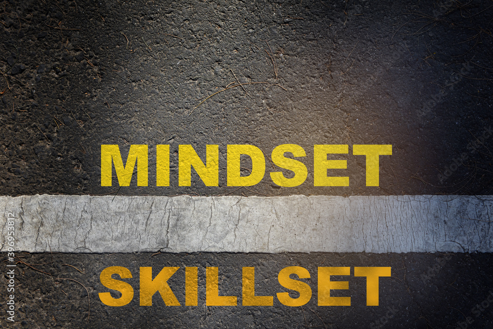 Mindset and skillset written on asphalt road surface with white ...