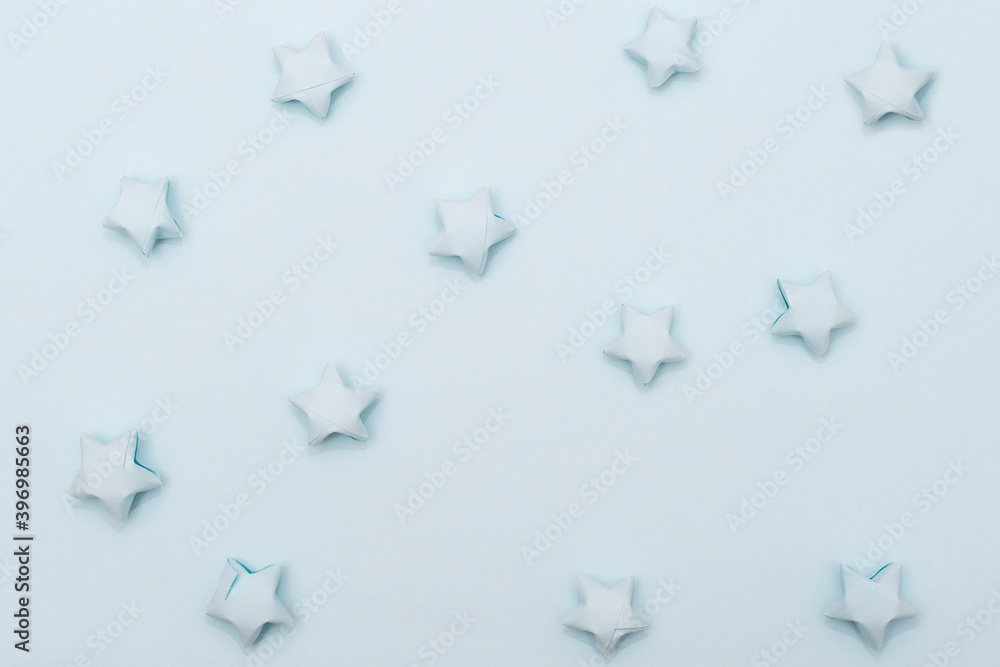 Solid light blue background with paper stars in a children's style ...