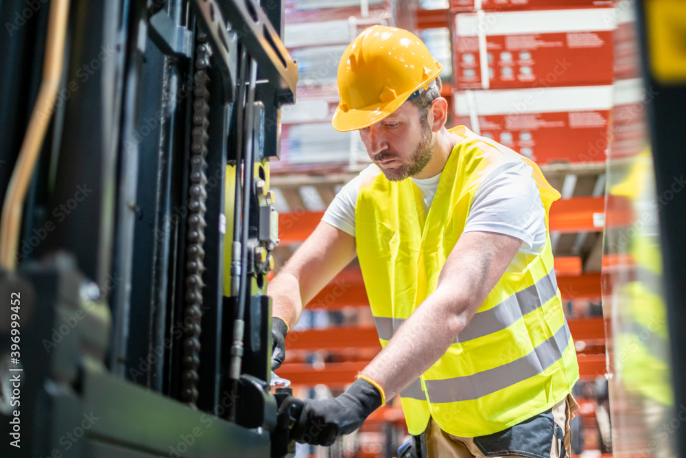 Mechanic repairing forklift in warehouse Stock Photo | Adobe Stock