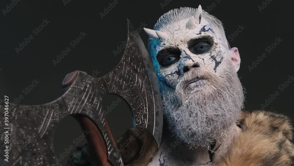 Evil and violent dead warrior with white pale skin and blue eyes raises ...
