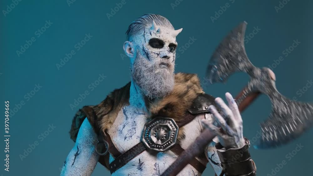 Mythical evil undead barbarian with horns and frosty skin puts his huge ...