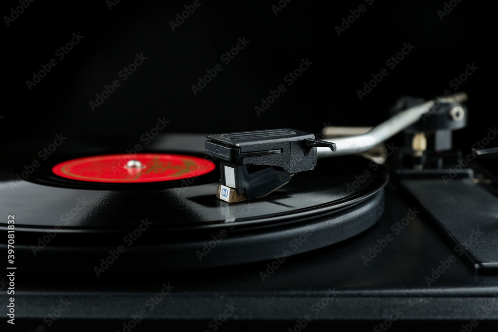 vinyl record on a turntable. turntable head close-up on black ...