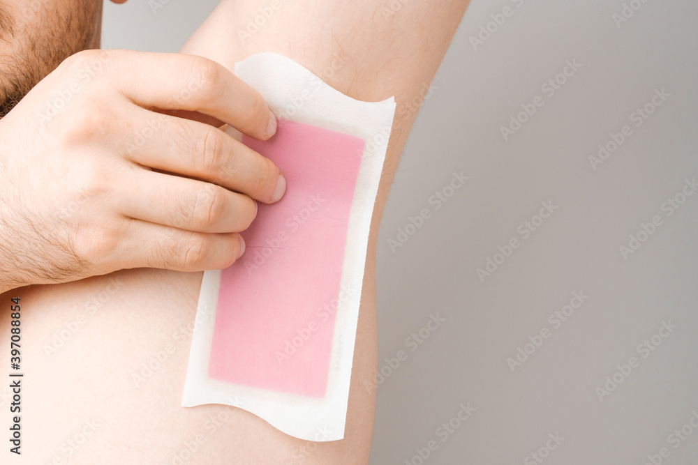 Man remove hair using wax strip from armpit. Unshaved armpits or ...